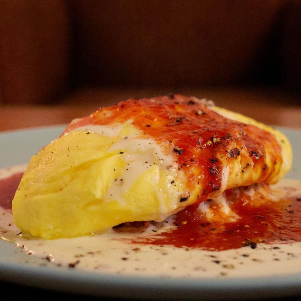 青森県弘前市にある「antique&café ROTTO」の「フワフワ卵のオムライス 〜自家製ケチャップとチーズソース〜サラダ付き」